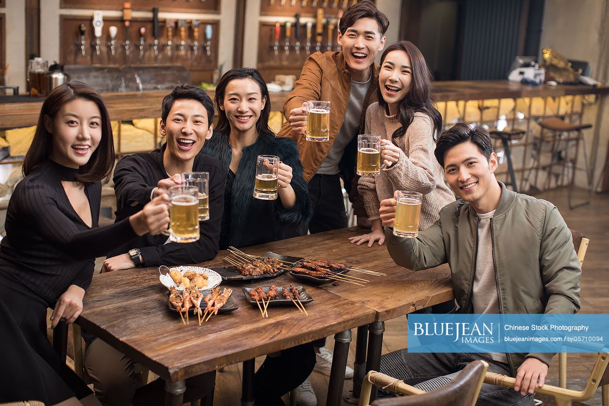 Happy Chinese friends toasting in bar-High-res stock photo for download