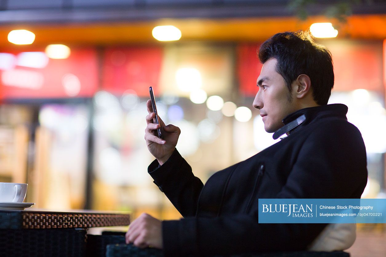 Young Chinese man using smart phone-High-res stock photo for download