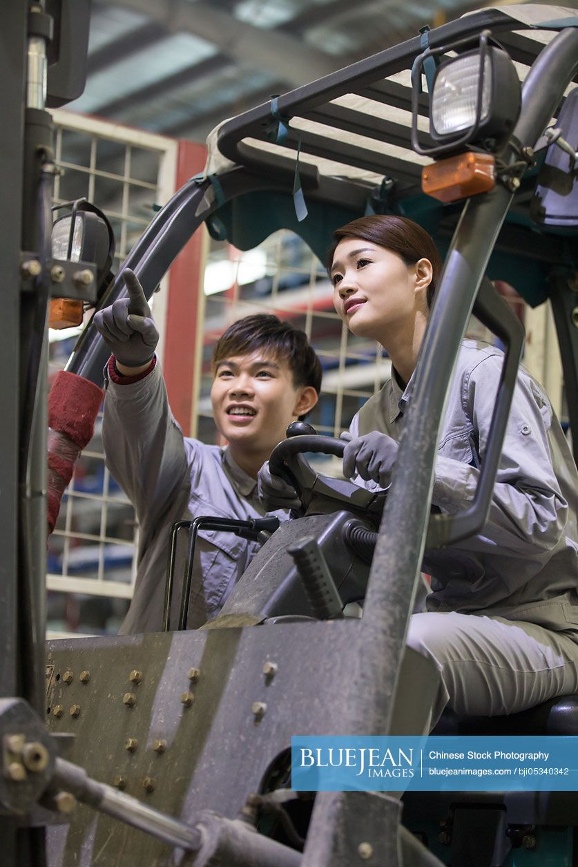 Confident Chinese workers driving forklift in the factory-High-res ...