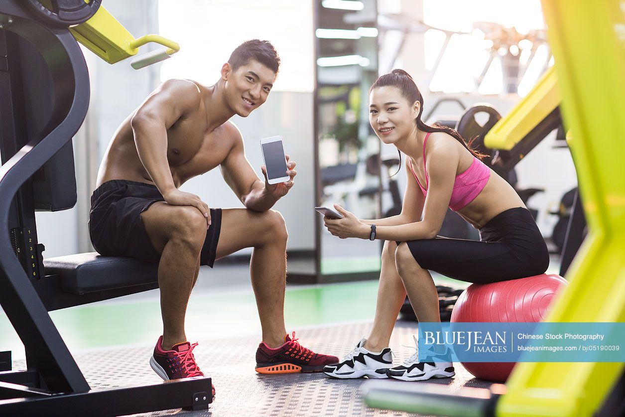 Young Chinese couple resting at gym-High-res stock photo for download
