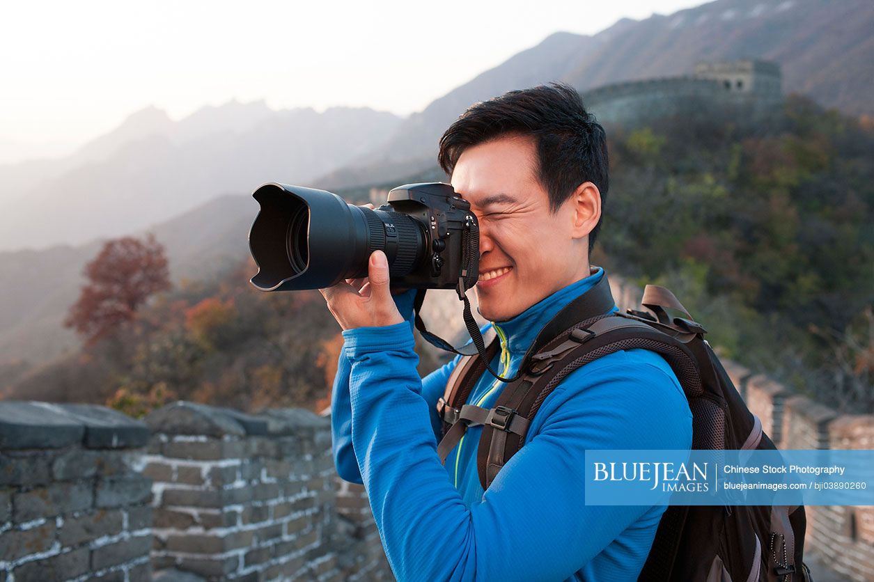 Young Chinese man photographing on Great Wall-High-res stock photo for ...