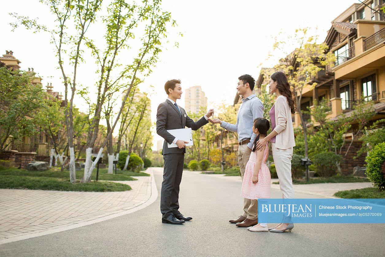 Chinese realtor giving young family keys to new house-High-res stock photo for download