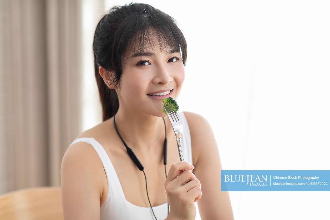 Young Chinese woman having breakfast at home-High-res stock photo for download