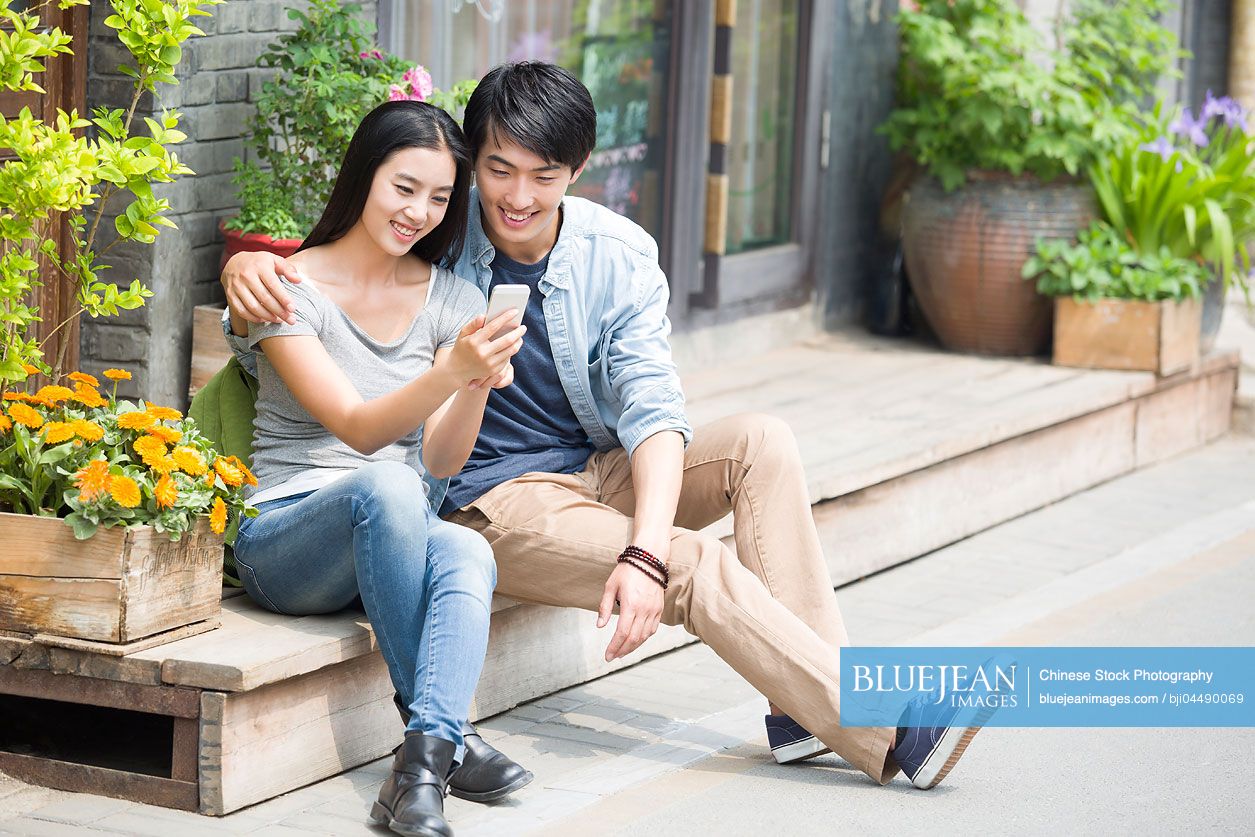 Young Chinese couple using smart phone-High-res stock photo for download