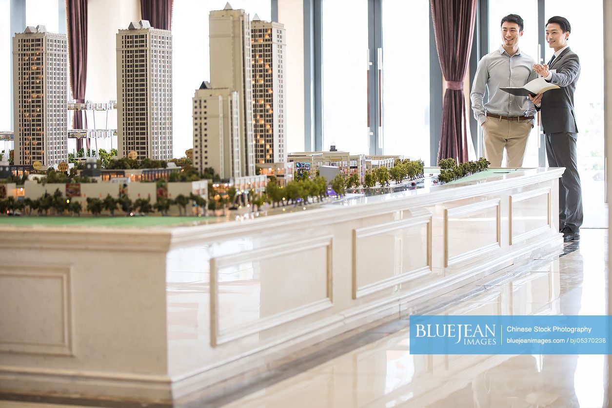 Chinese realtor showing architectural model to young man-High-res stock ...