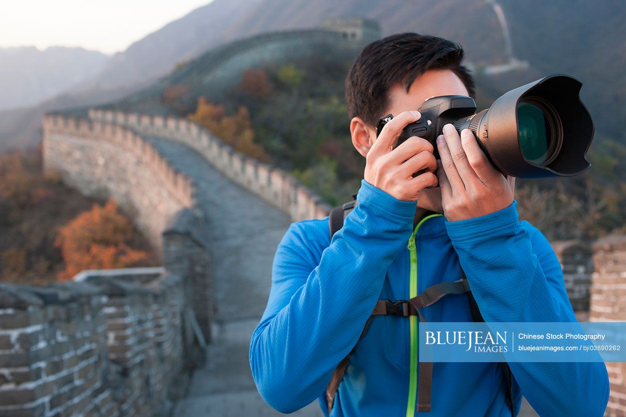 Young Chinese man photographing on Great Wall-High-res stock photo for ...