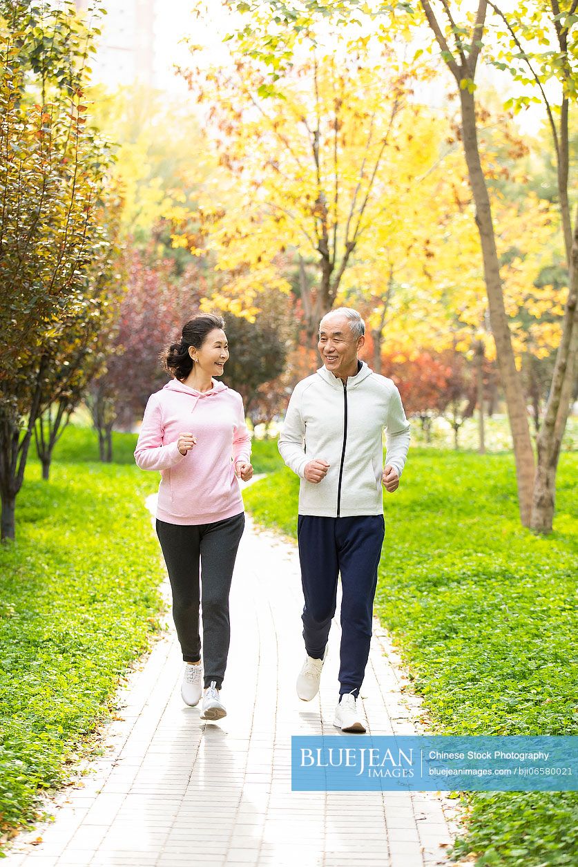 Happy senior Chinese couple running in the park-High-res stock photo for download