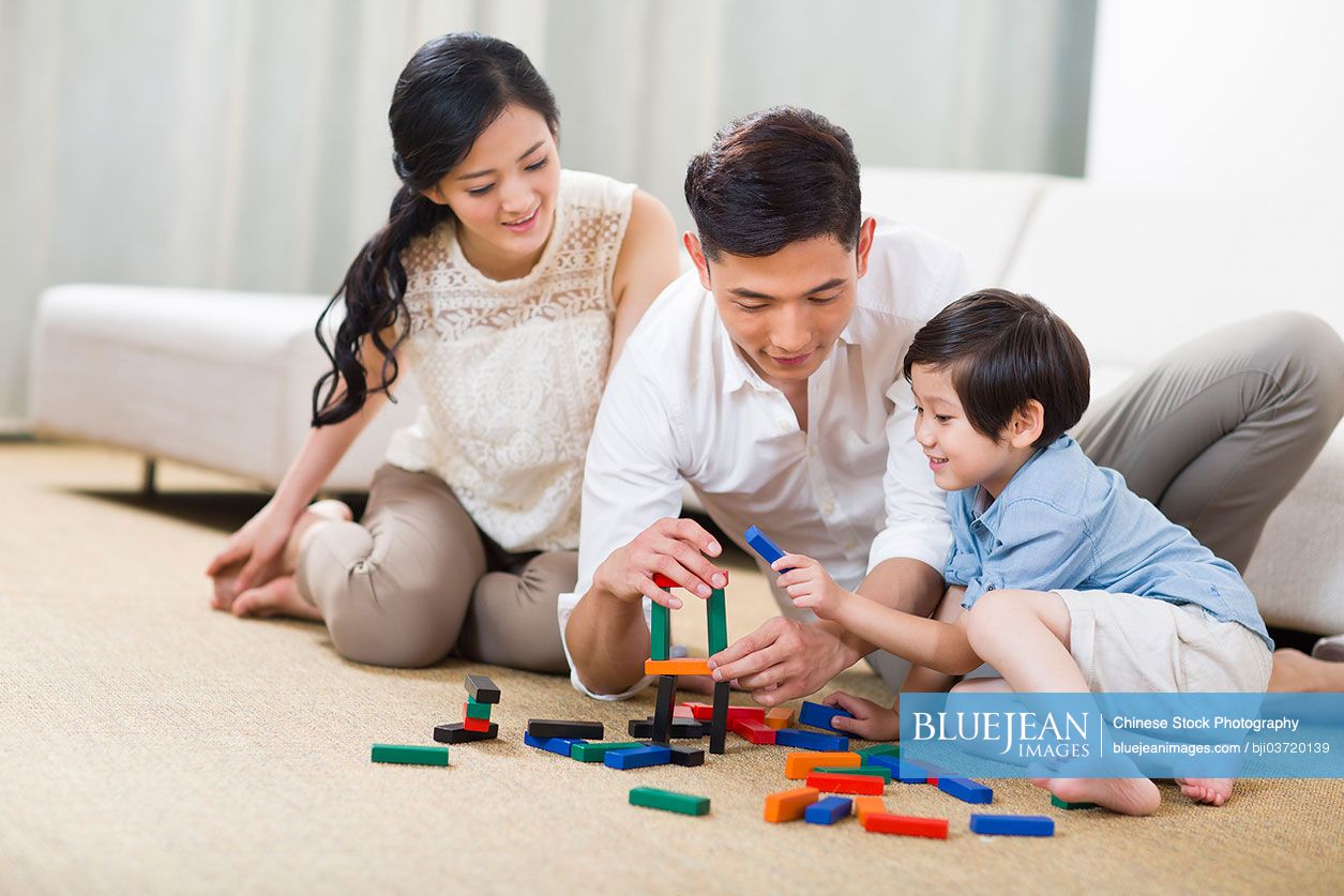 Young Chinese family playing building block in living room-High-res ...