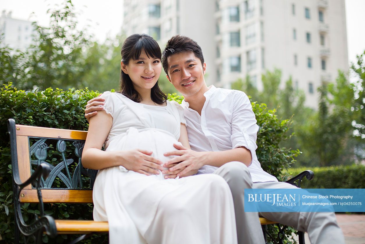 Pregnant Chinese woman and her husband sitting on bench-High-res stock ...