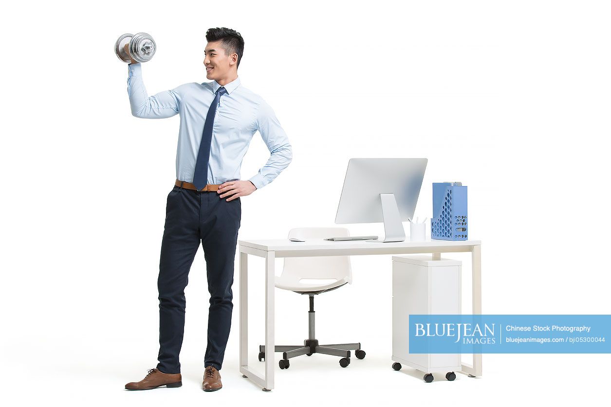 Young Chinese Businessman Lifting Weights In Office High res Stock young-chinese-businessman-lifting-weights-in-office-high-res-stock
