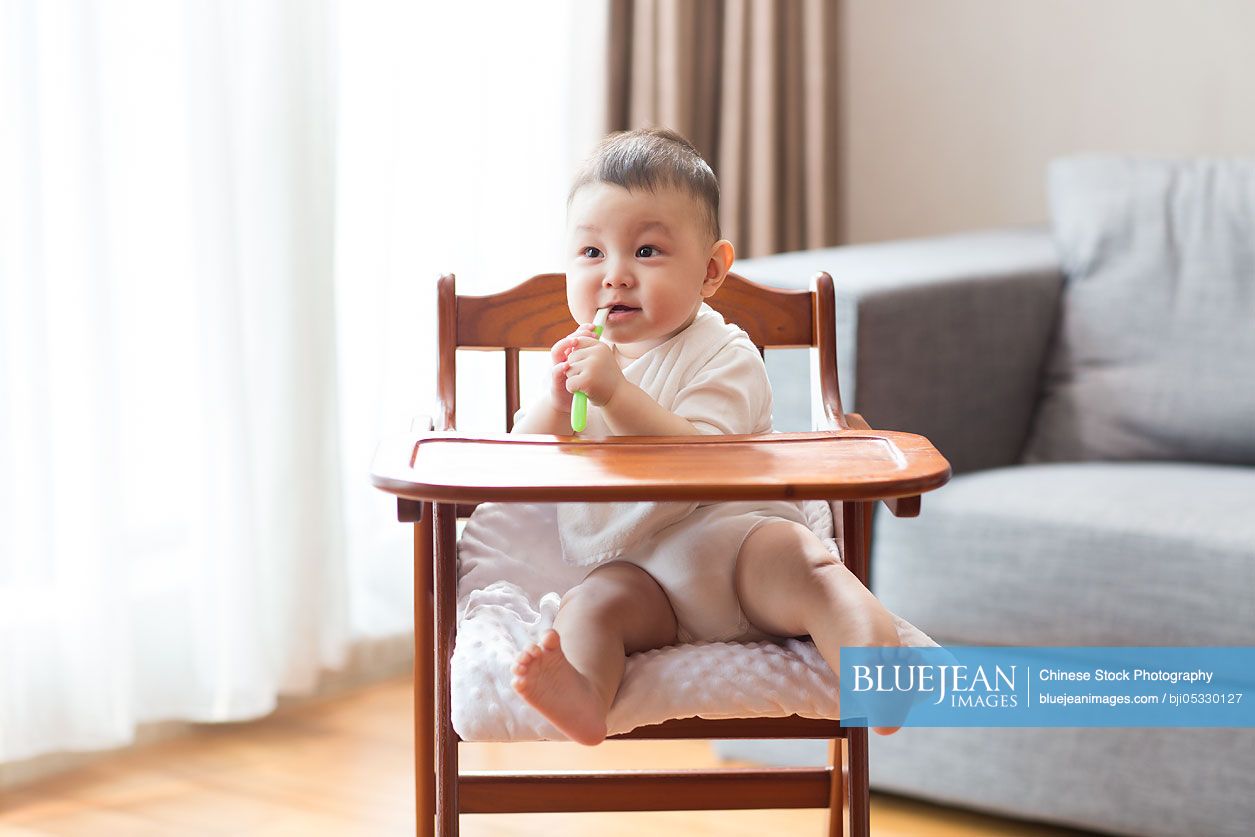 Cute Chinese baby boy sitting in high chair-High-res stock photo for ...