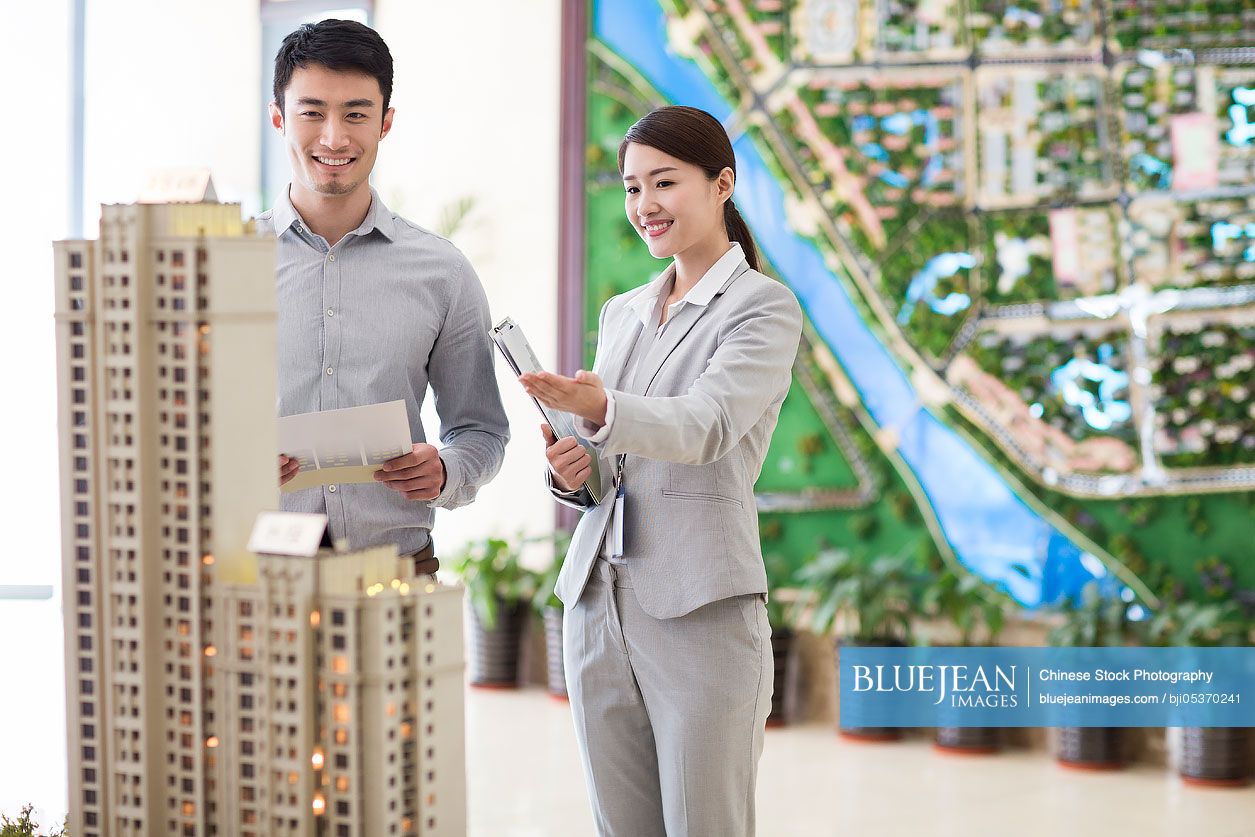 Chinese realtor showing architectural model to young man-High-res stock ...