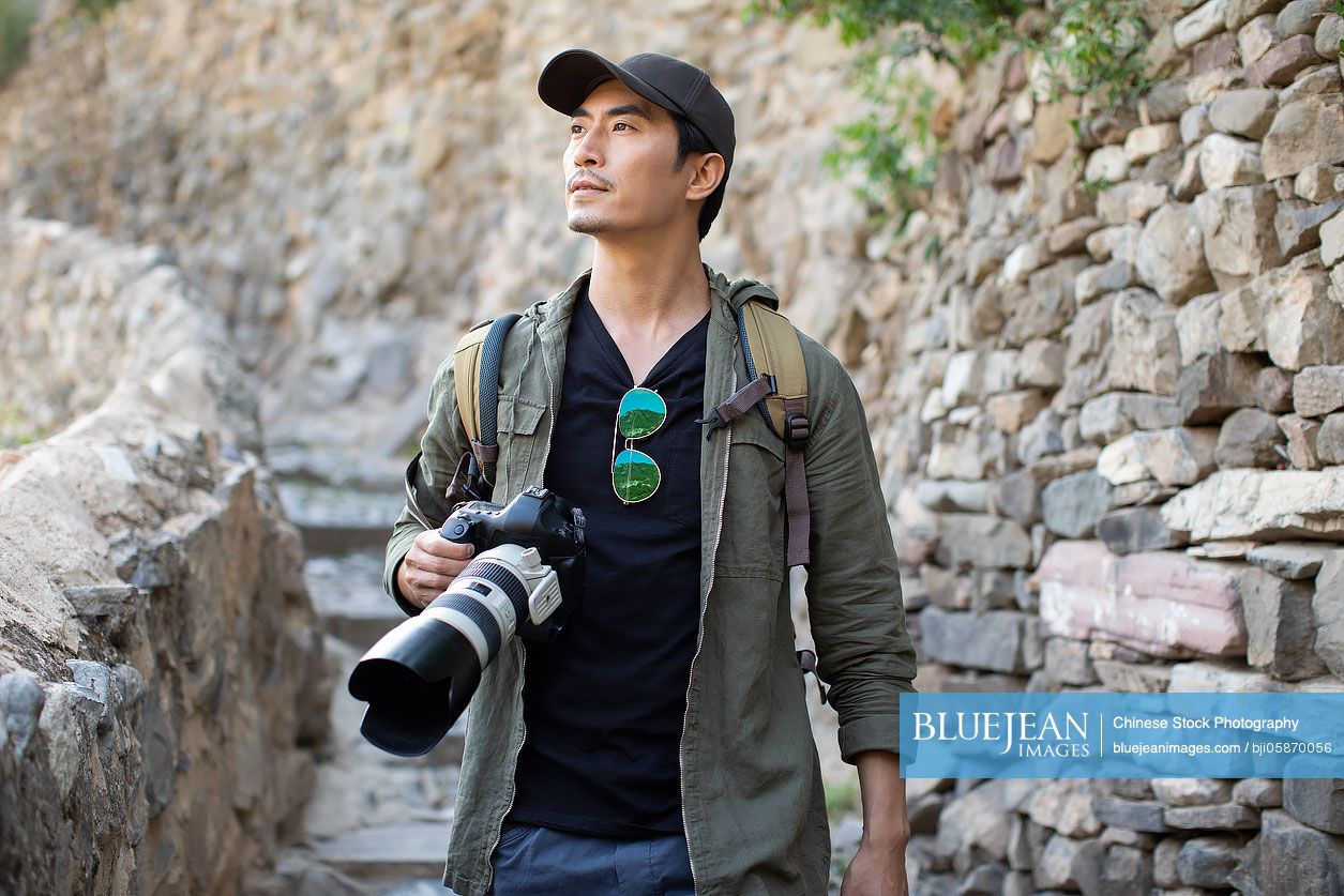 Chinese Photographer walking in village-High-res stock photo for download