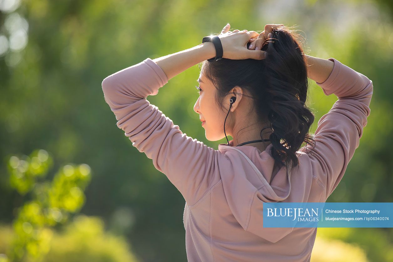 Young Chinese woman preparing for morning run in park-High-res stock ...