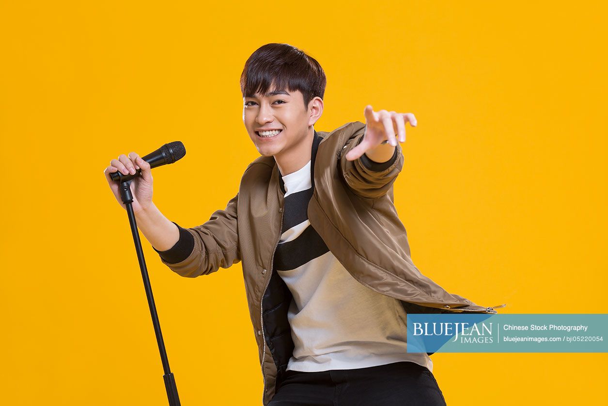 Cheerful young Chinese man singing with microphone-High-res stock photo ...