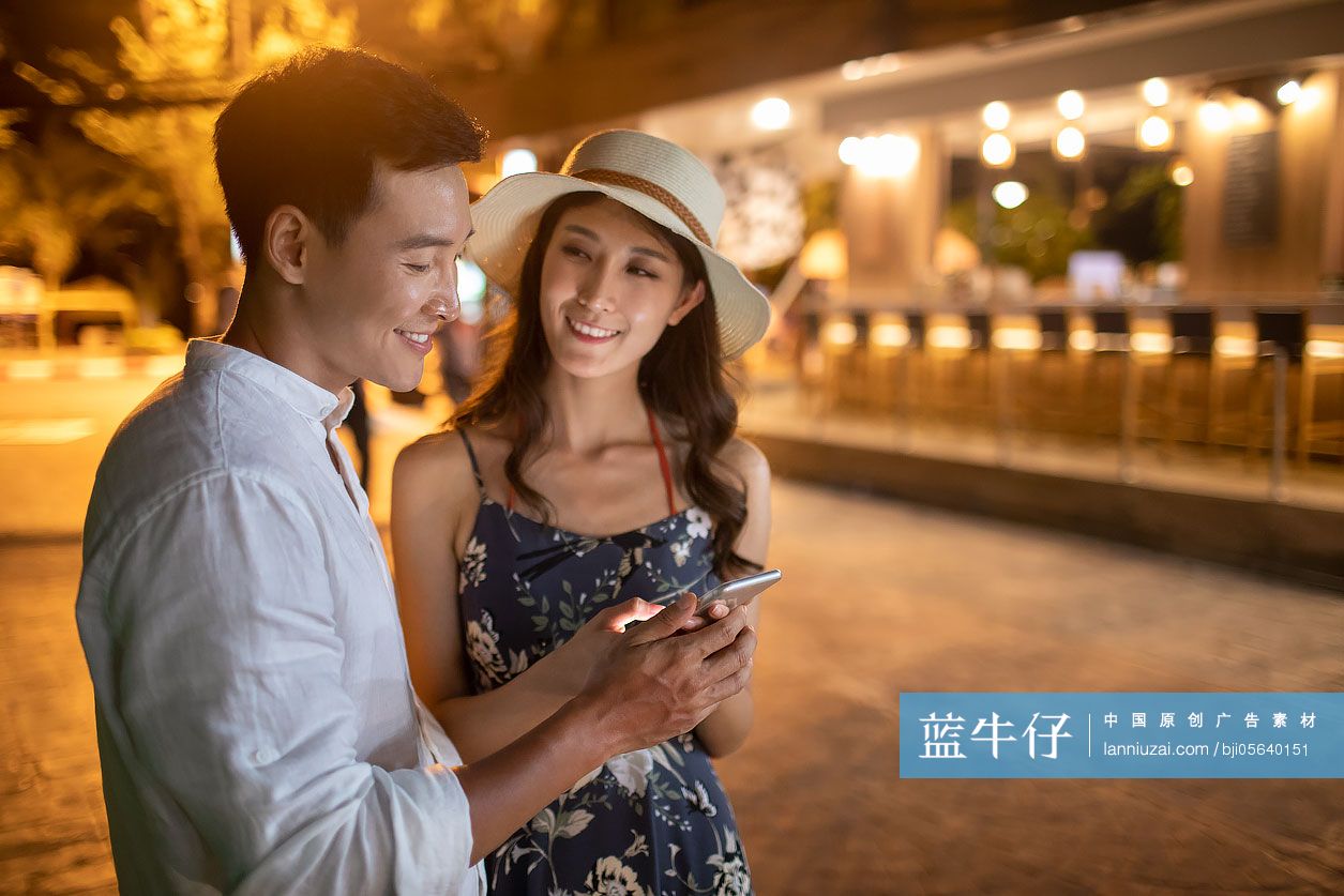 快乐的年轻情侣使用手机 蓝牛仔影像 中国原创广告影像素材