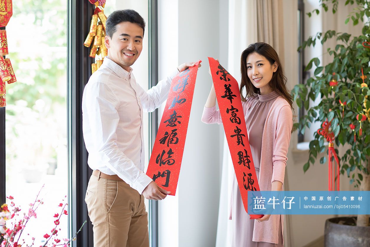 快乐的年轻夫妇拿着新年对联 蓝牛仔影像 中国原创广告影像素材