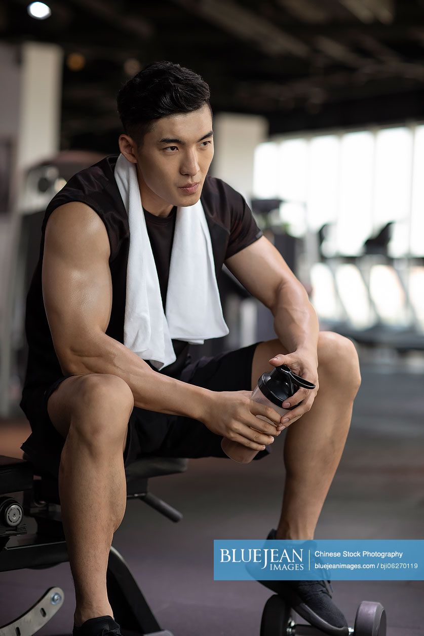 Young Chinese man taking a break from workout at gym-High-res stock ...