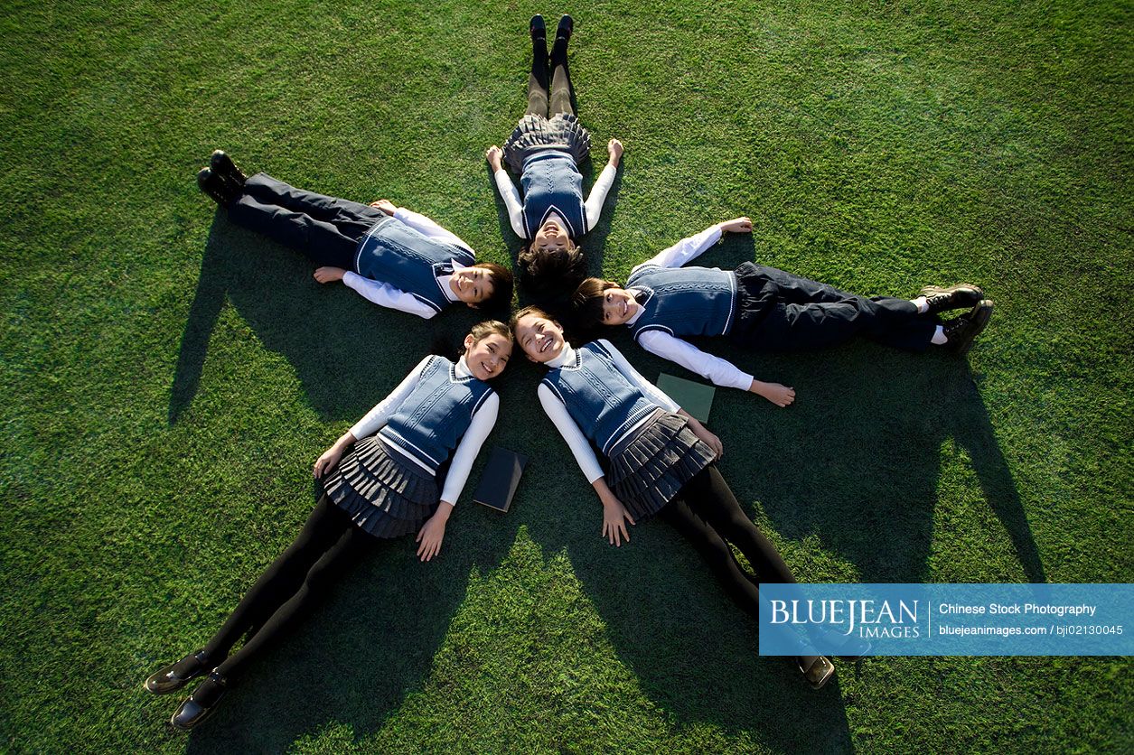 Five Chinese classmates lying in a star shape on grass-High-res stock ...