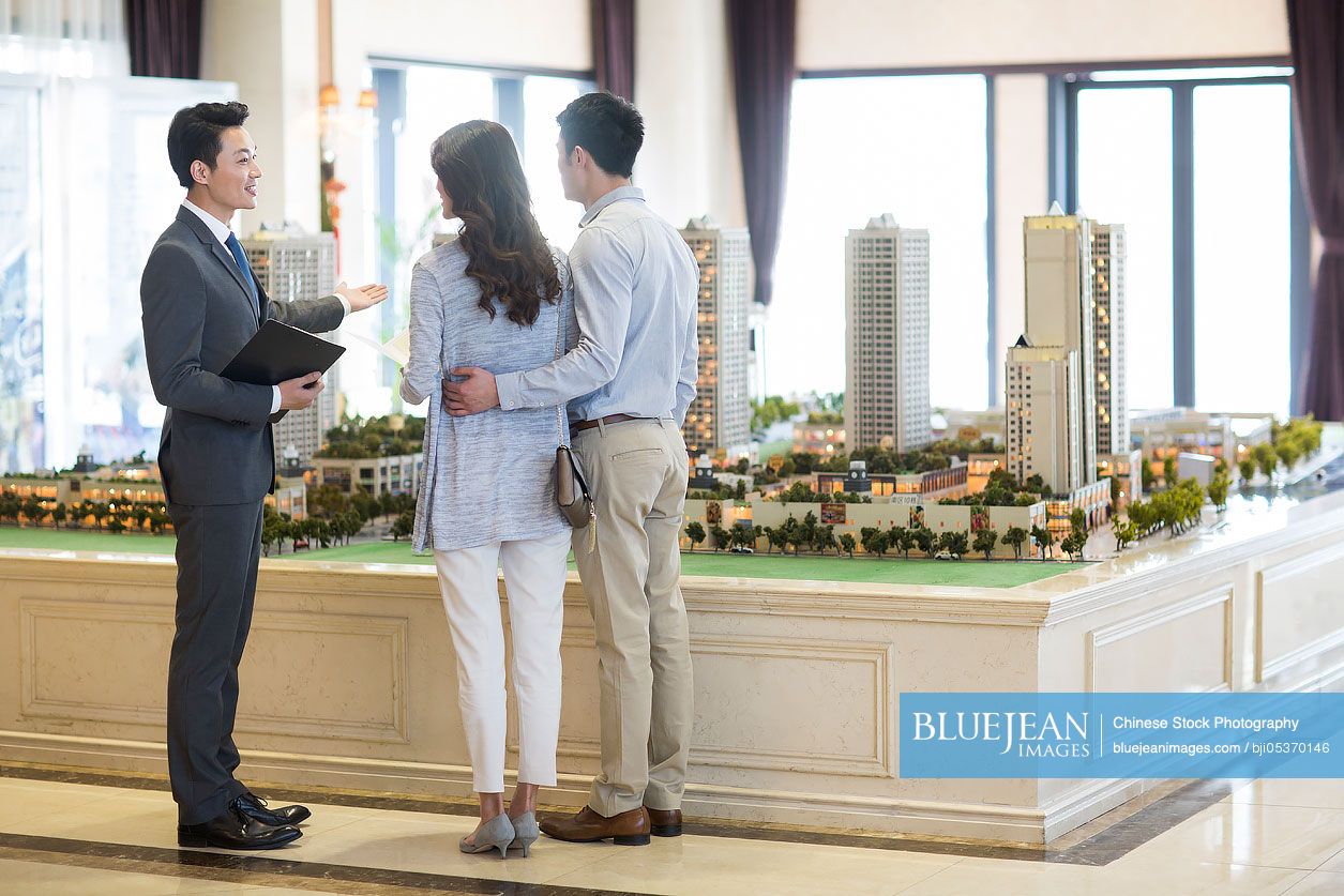 Happy young Chinese couple buying new house from sales center-High-res ...