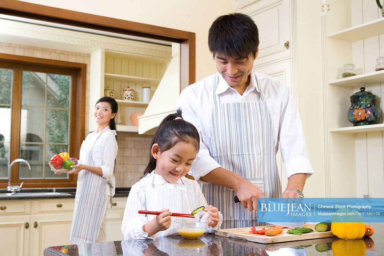 A Chinese family of three cooking in kitchen-High-res stock photo for download