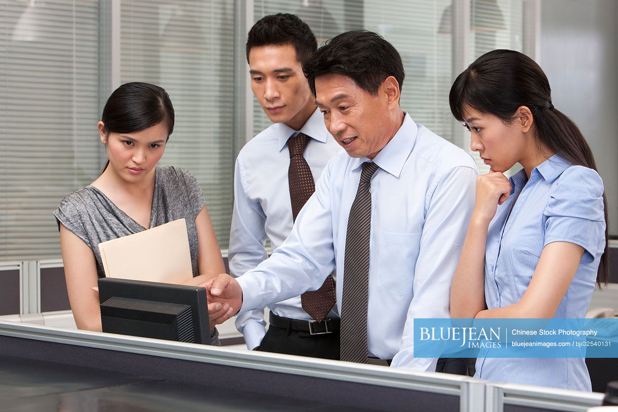 Senior Chinese colleague helping co-workers-High-res stock photo for download