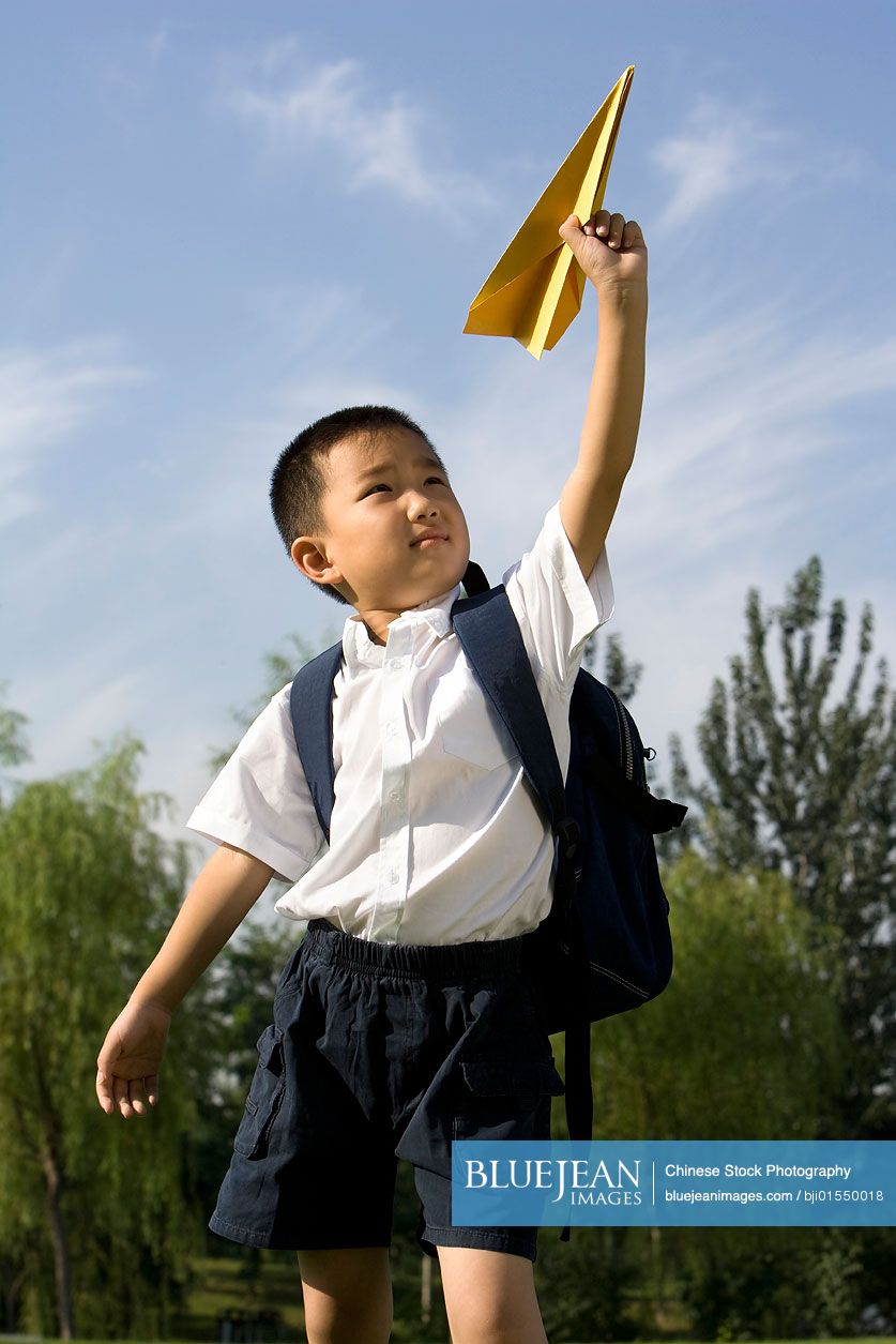 Chinese boy playing with a paper airplane-High-res stock photo for download