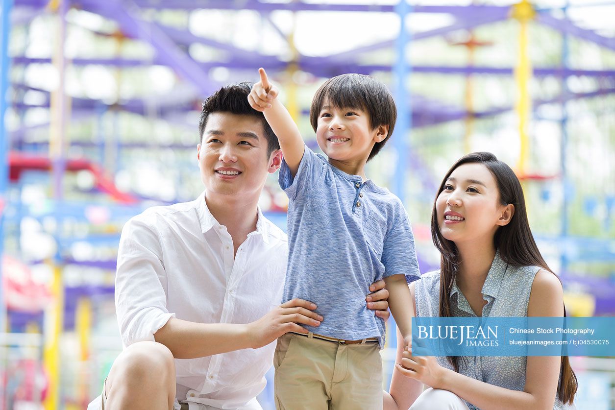 Happy young Chinese family playing in amusement park-High-res stock ...