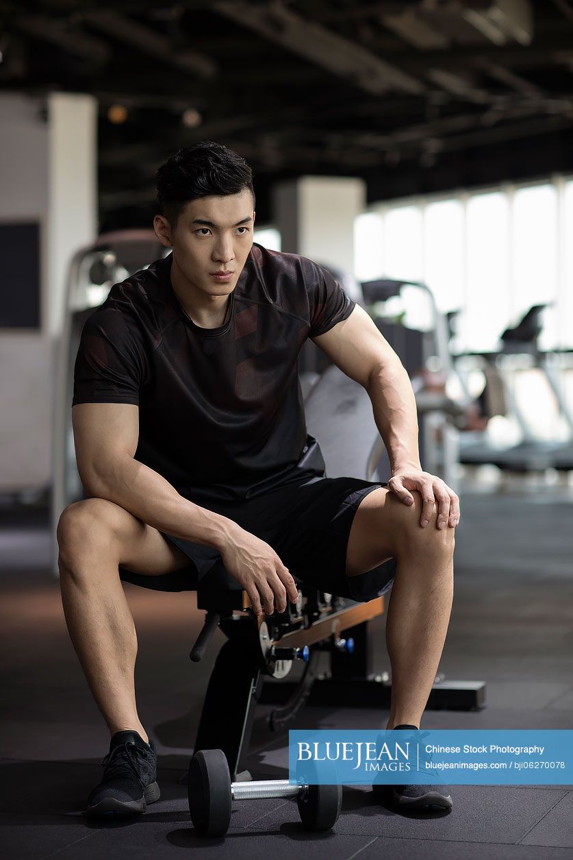 Young Chinese man working out with dumbbell at gym-High-res stock photo ...