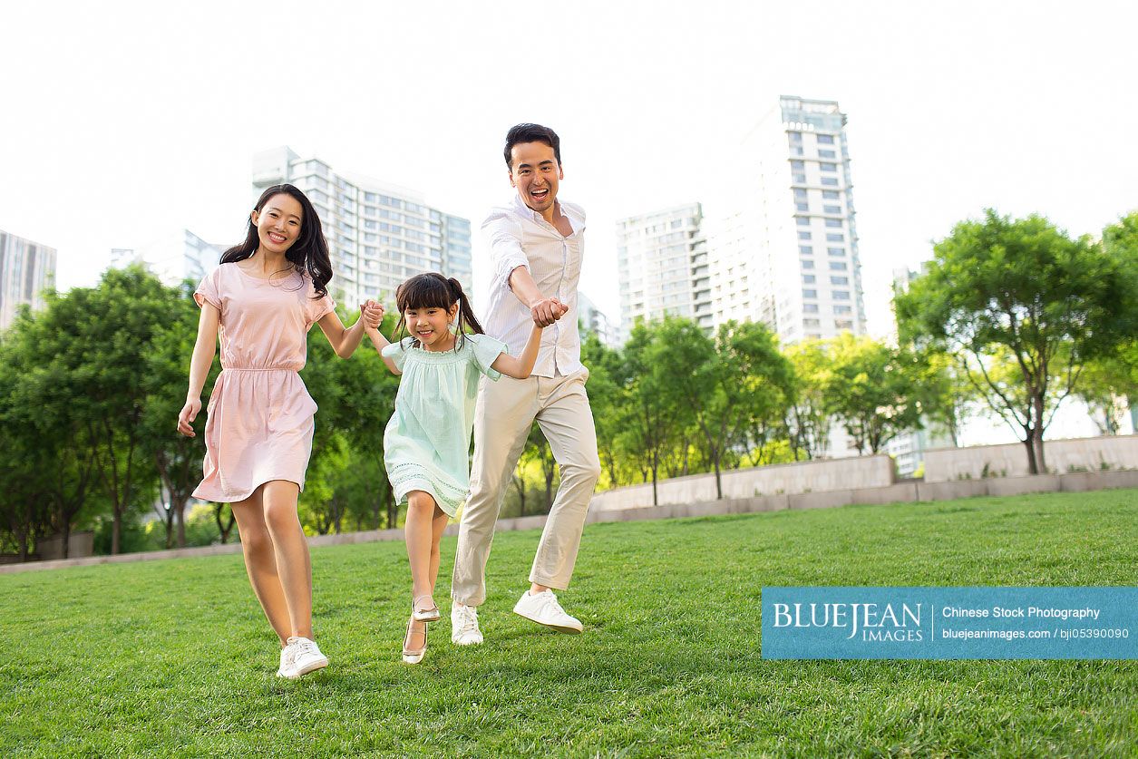 Happy young Chinese family playing in park-High-res stock photo for download