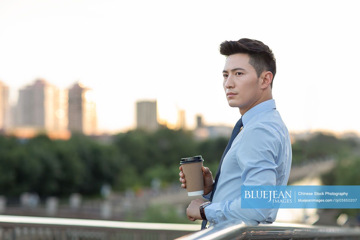 Young Chinese businessman holding a cup of coffee-High-res stock photo ...