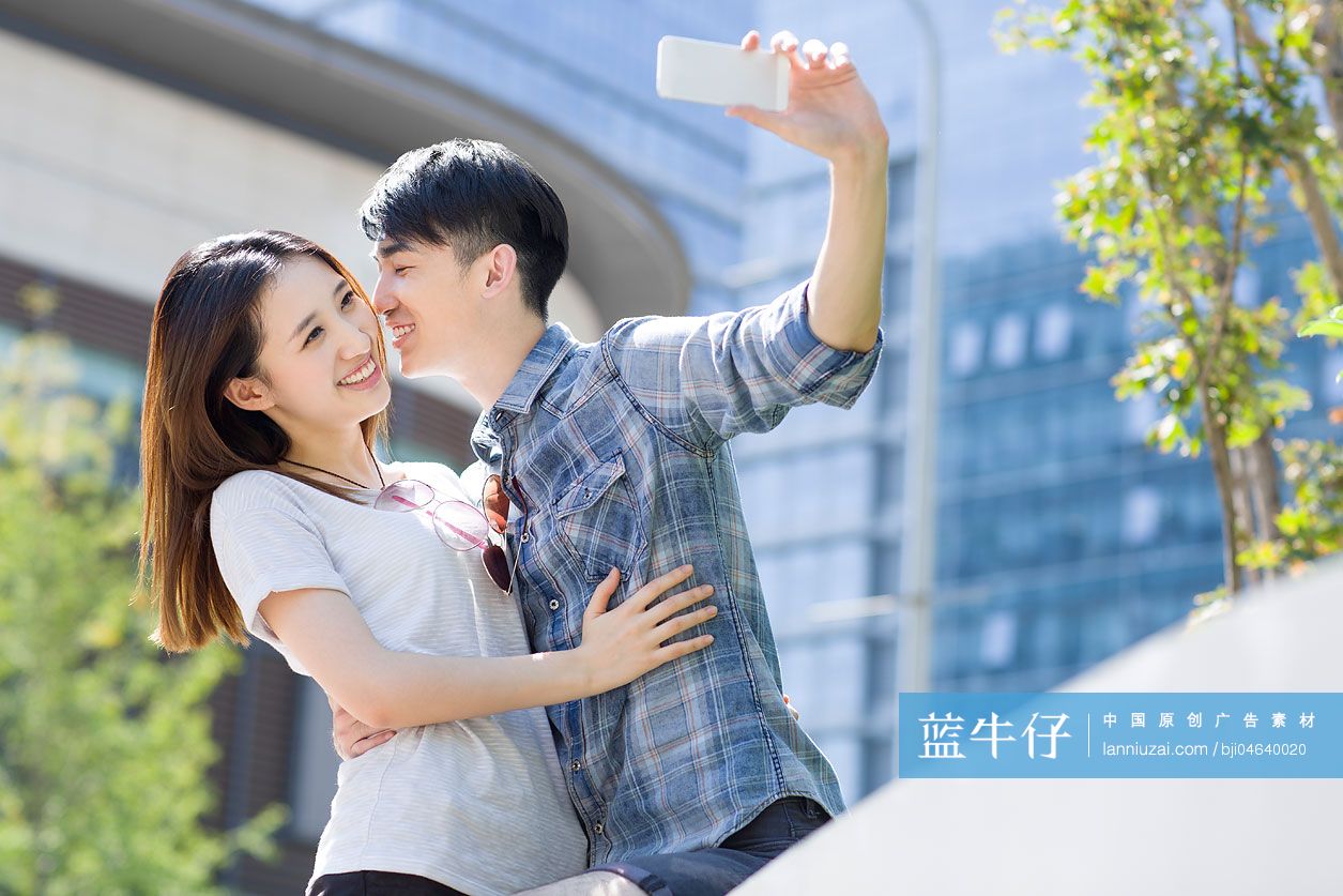 快乐的年轻情侣用手机自拍 蓝牛仔影像 中国原创广告影像素材 