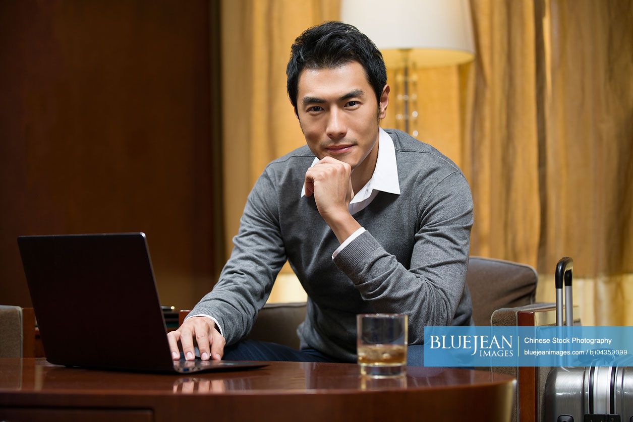Young Chinese businessman using laptop in hotel room-High-res stock ...