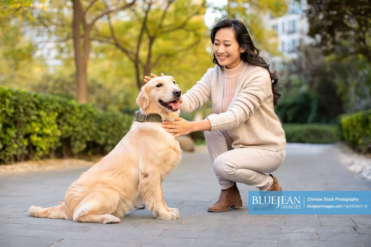 Happy young Chinese woman with dog-High-res stock photo for download
