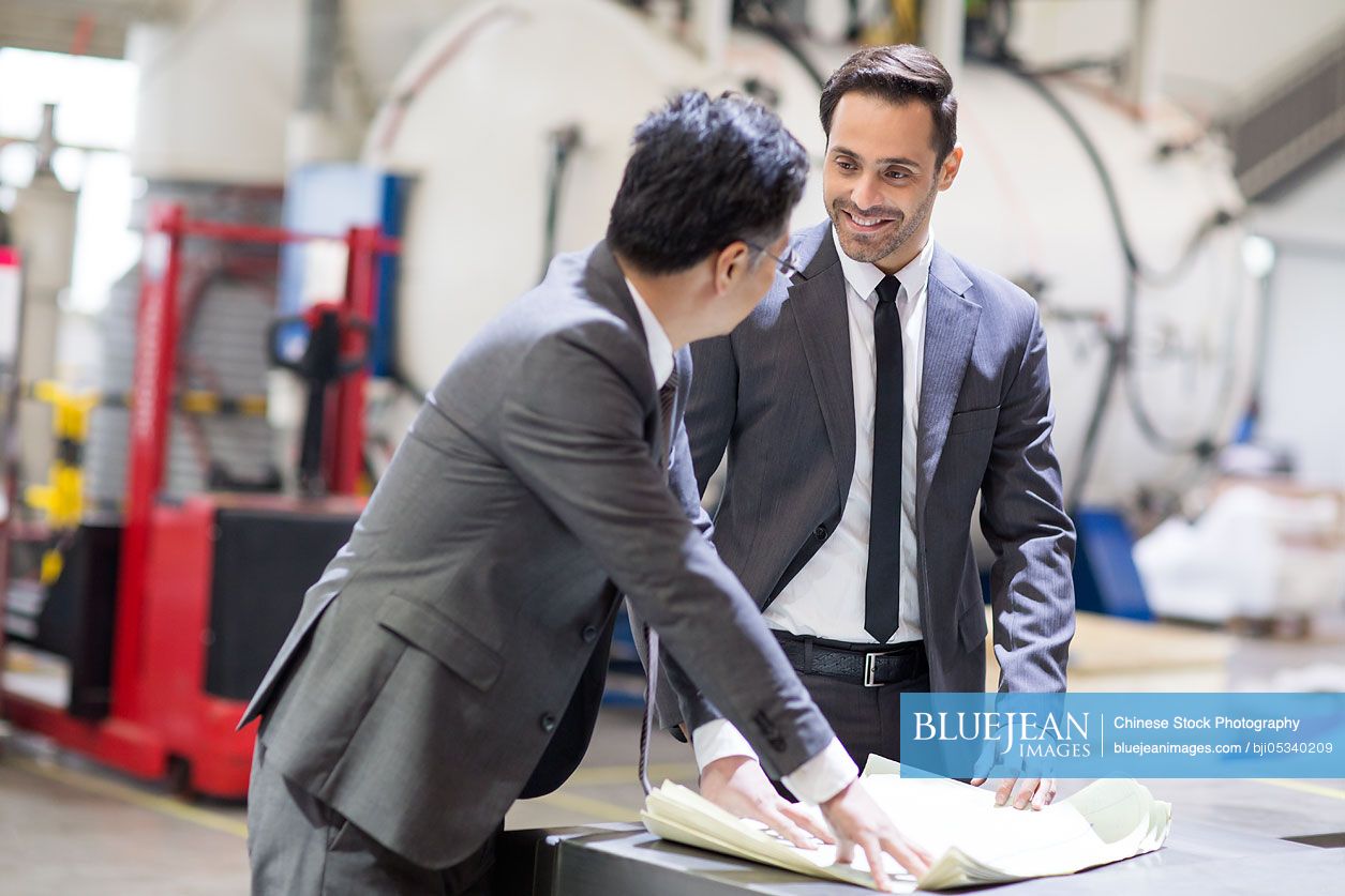 Businessman and engineer talking in the factory-High-res stock photo ...