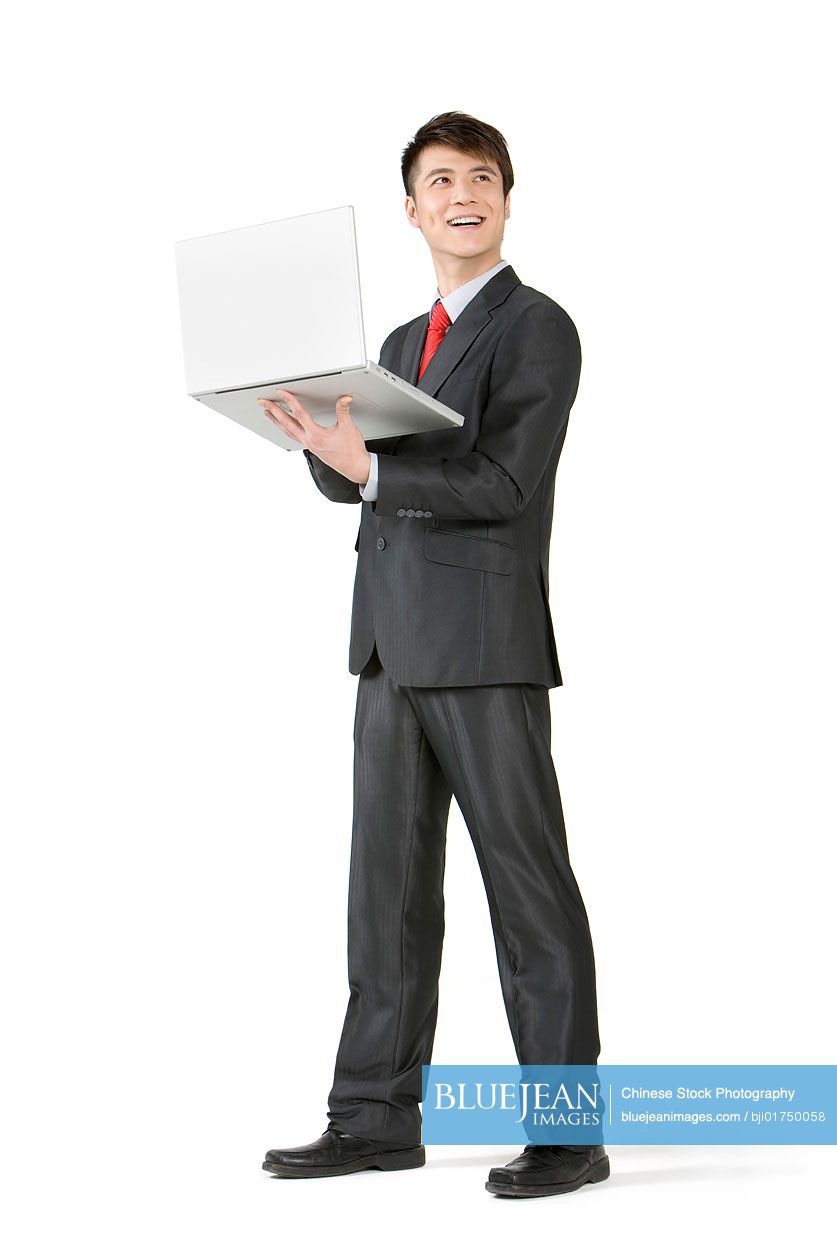 Young Chinese businessman holding a laptop-High-res stock photo for download