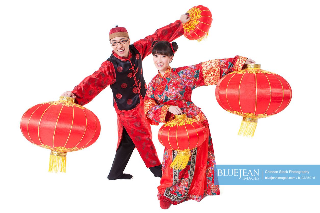 Cheerful young Chinese couple in Tang suit dancing with lantern in ...