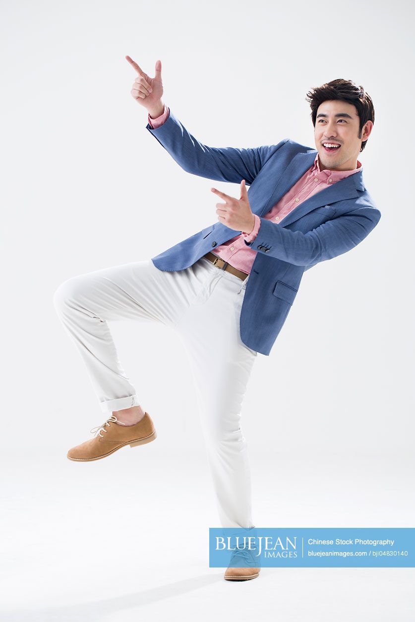 Fashionable young Chinese man pointing-High-res stock photo for download