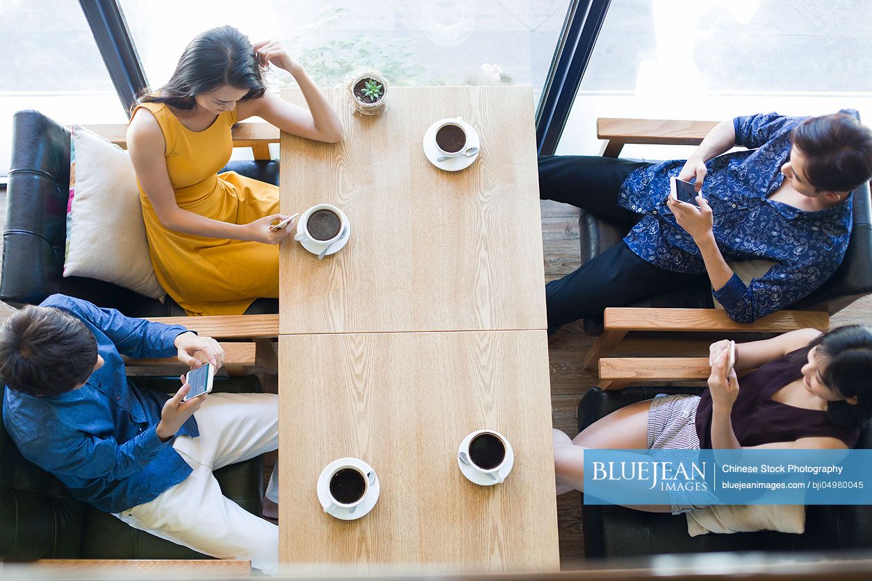 Young Chinese friends using smart phones in cafe-High-res stock photo ...