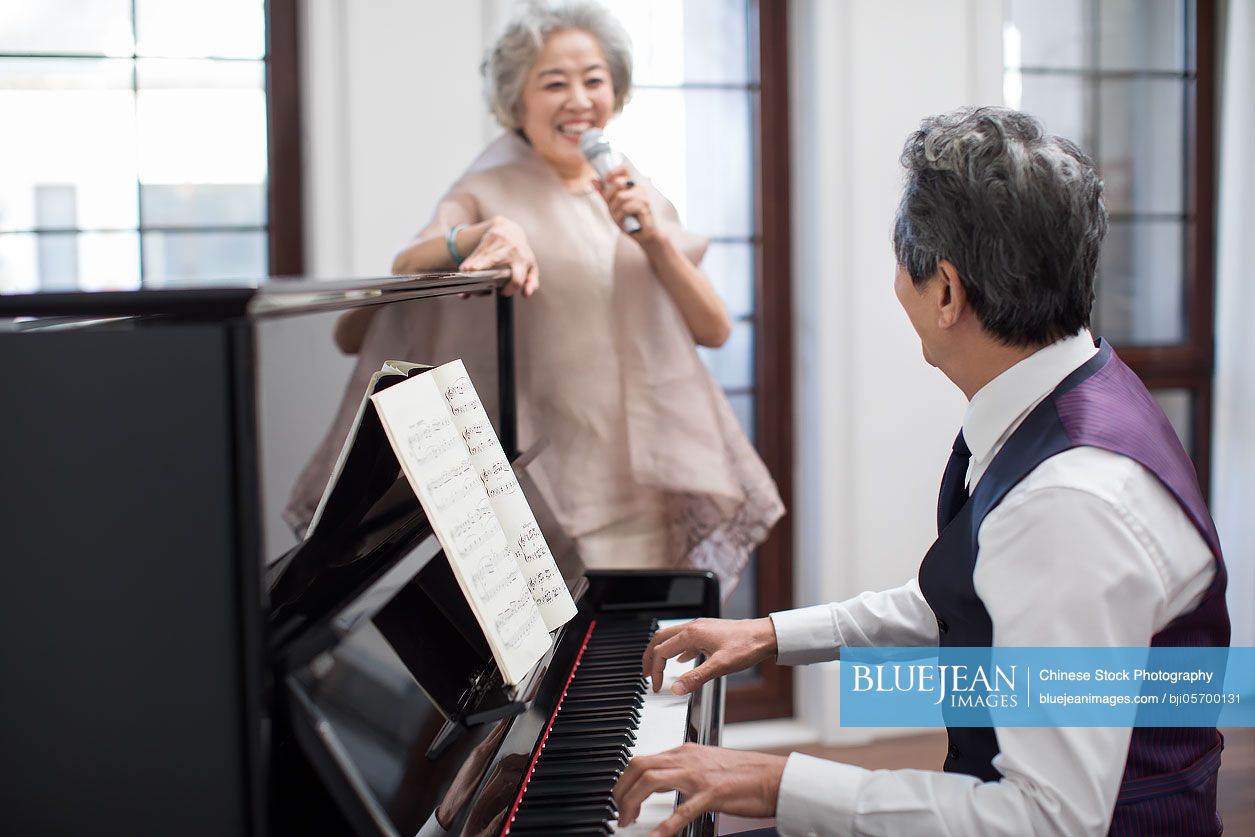 Noble Chinese senior couple singing and playing the piano together-High ...