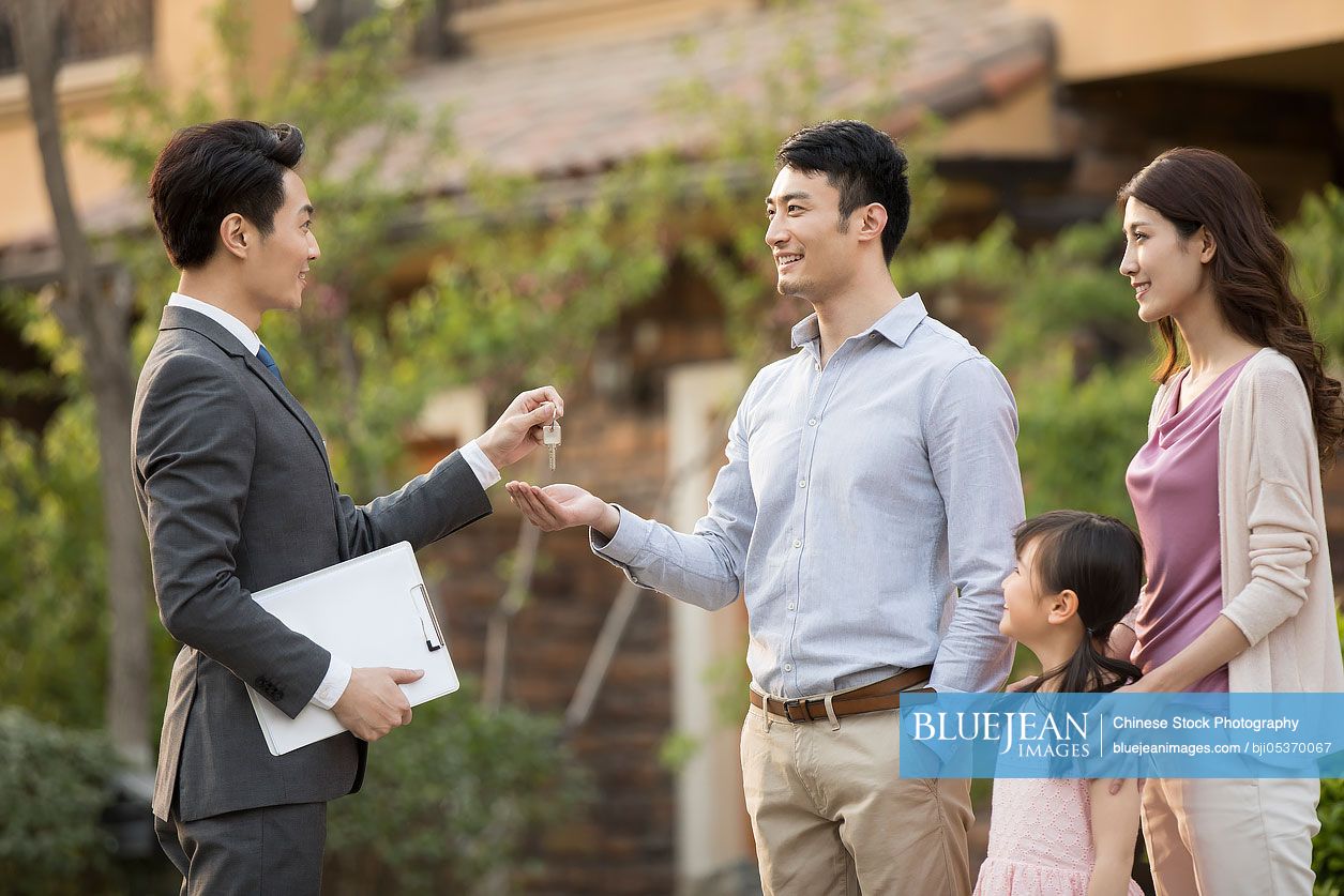 Chinese realtor giving young family keys to new house-High-res stock photo for download