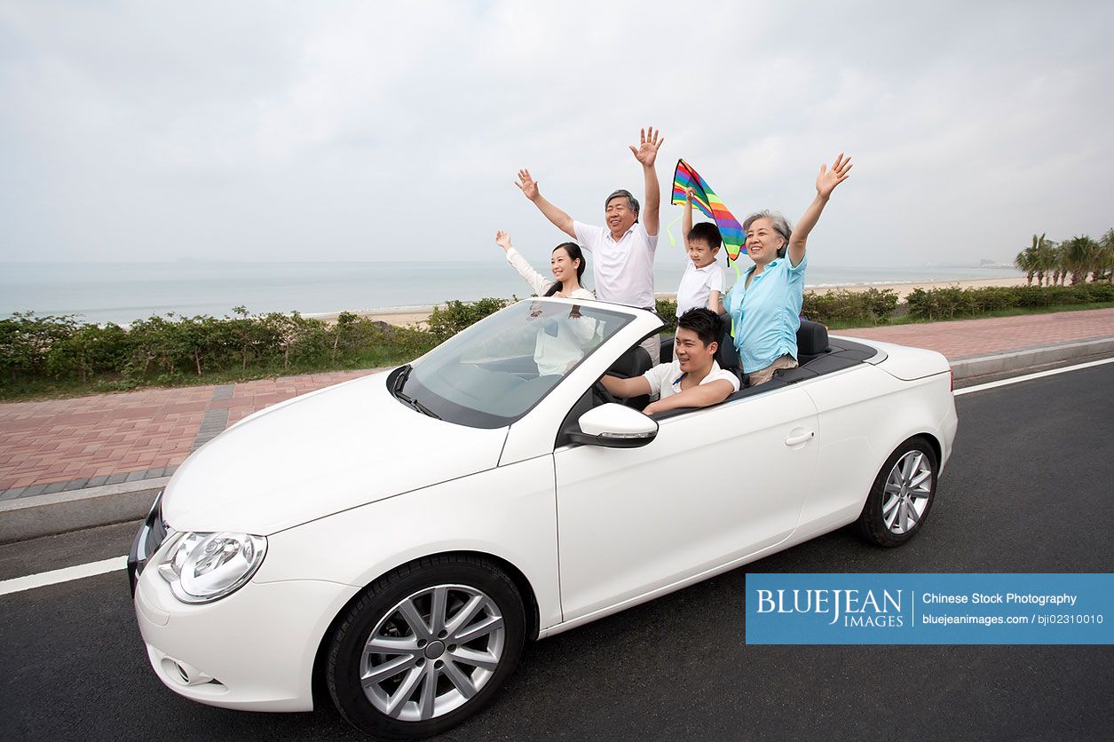 Happy Chinese family driving in a convertible-High-res stock photo for ...