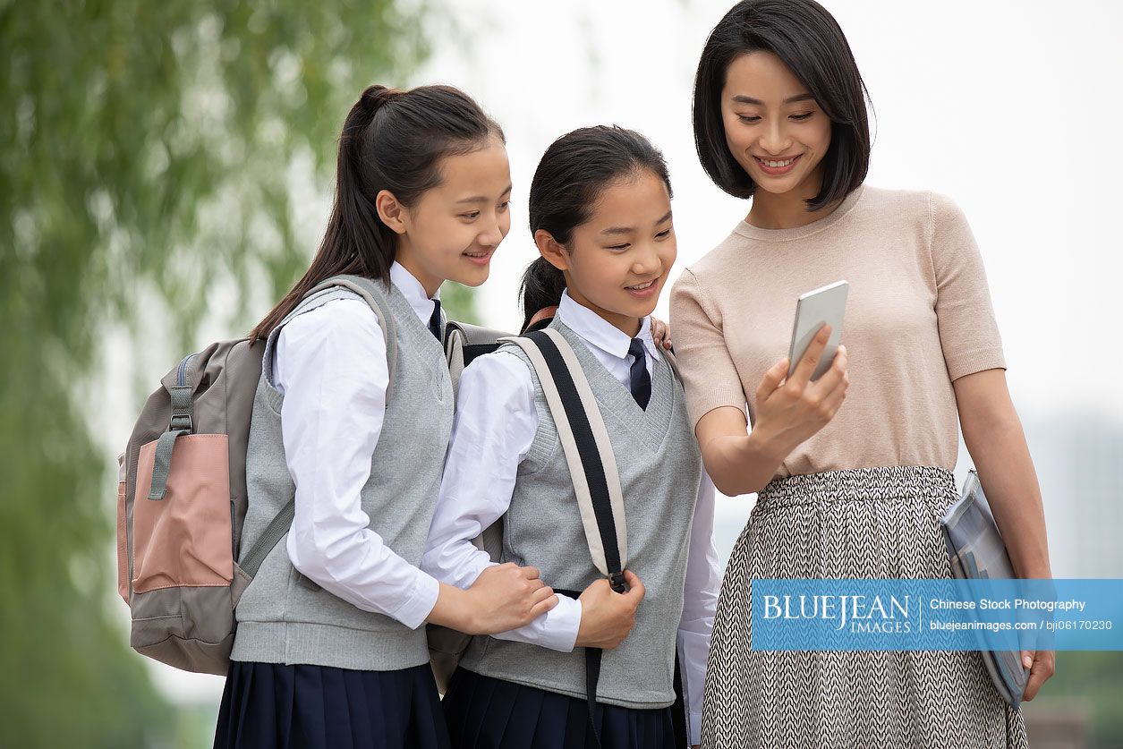 Chinese teacher showing students smartphone-High-res stock photo for ...