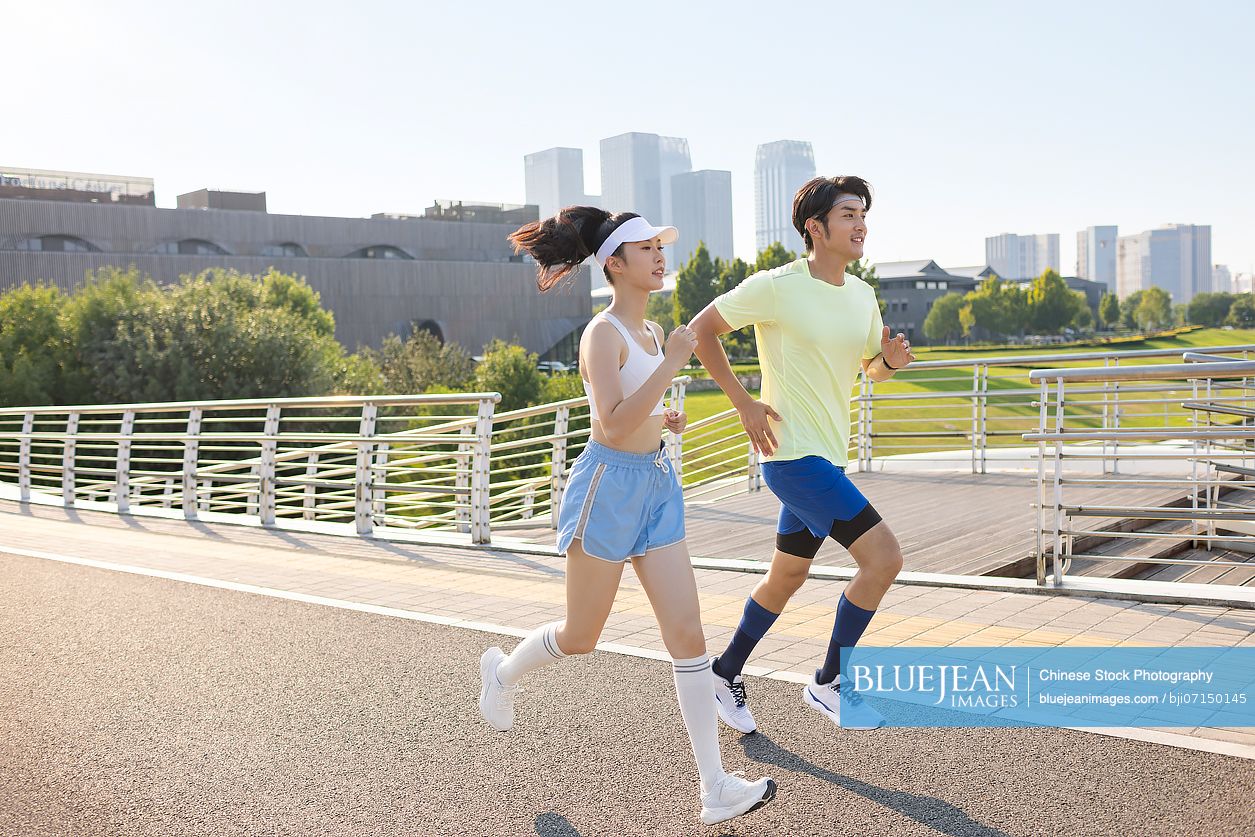 Happy young Chinese couple running in a park-High-res stock photo for download