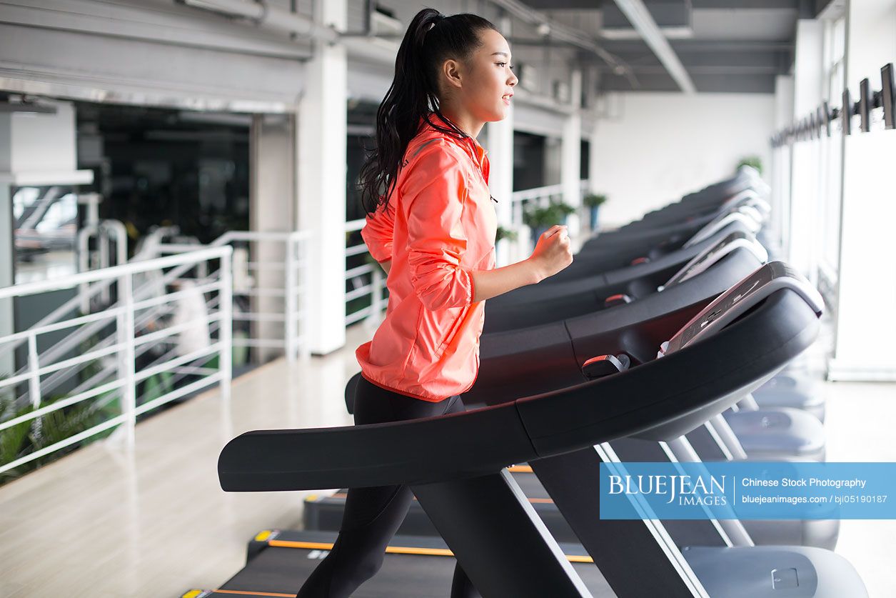 Young Chinese Woman Running On Treadmill In Gym High res Stock Photo Young Chinese Woman Running On Treadmill In Gym High res Stock Photo