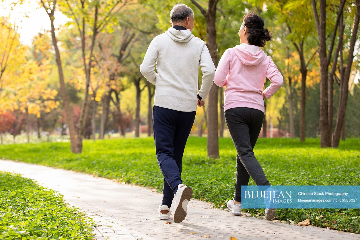 Happy senior Chinese couple running in the park-High-res stock photo for download