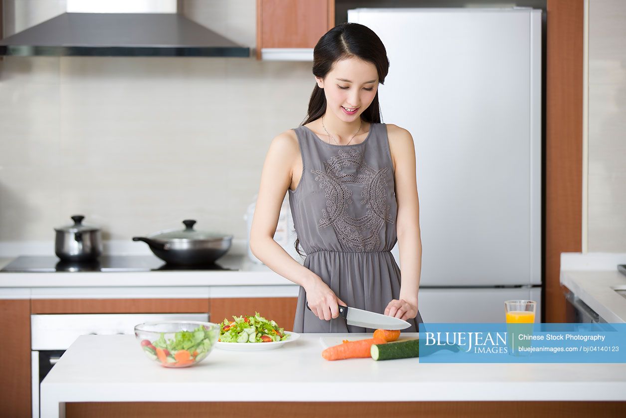 Young Chinese woman cooking in the kitchen-High-res stock photo for ...