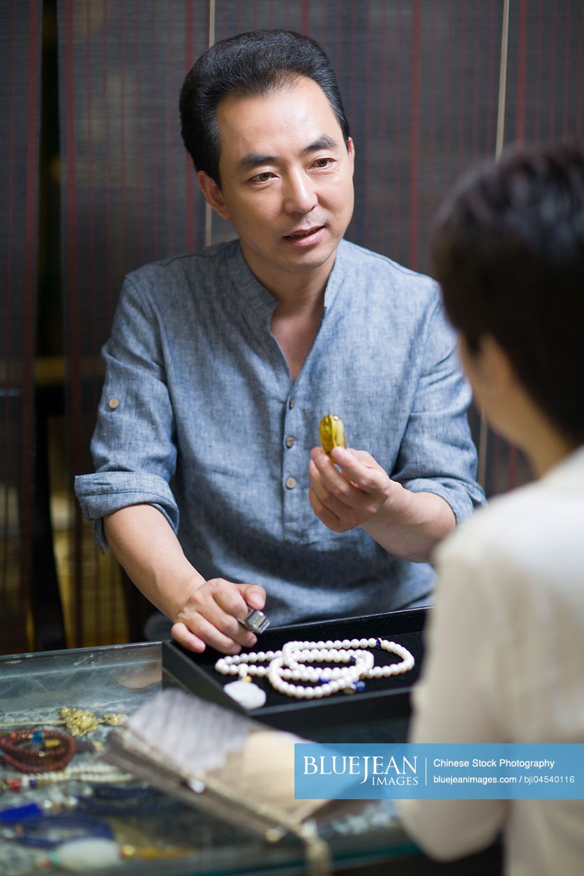 Chinese male jeweler talking with customer-High-res stock photo for download