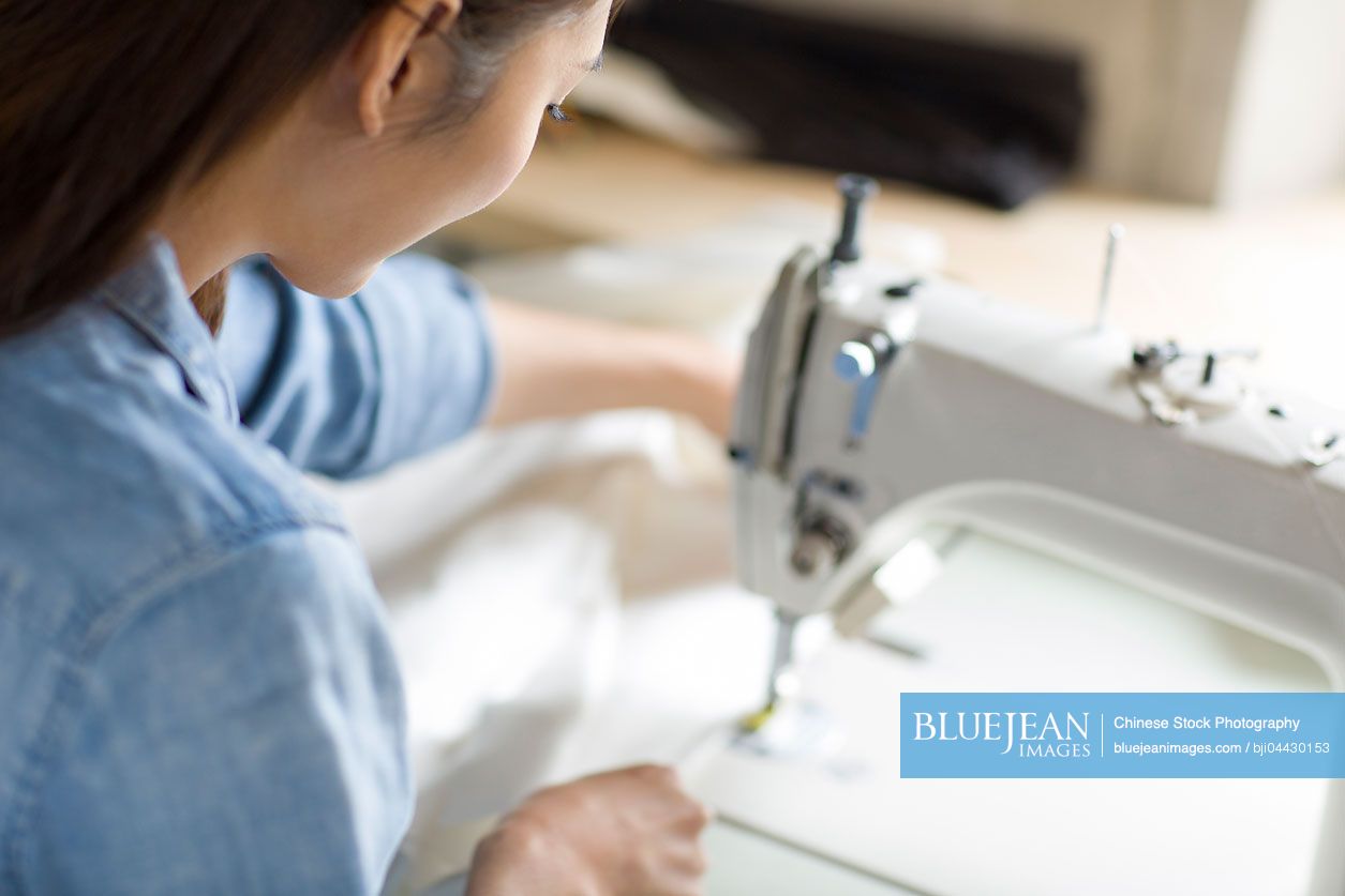 Chinese fashion designer using sewing machine-High-res stock photo for ...