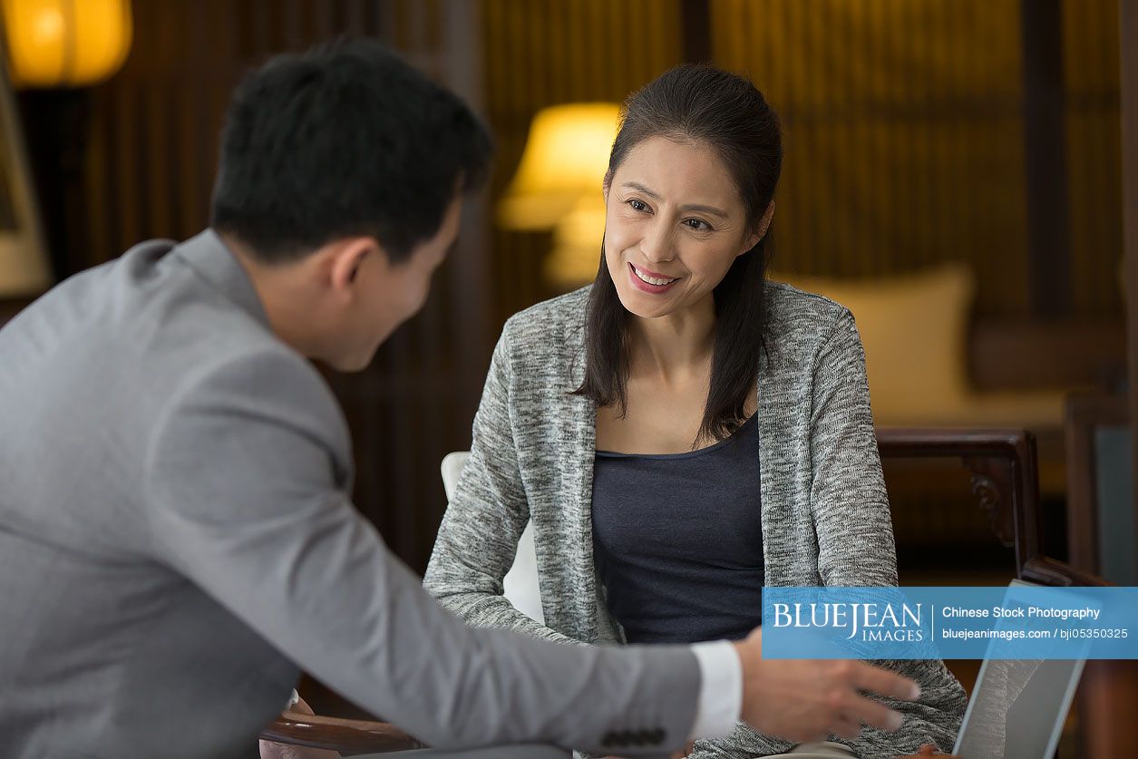 Confident Chinese financial consultant talking with a mature woman-High ...